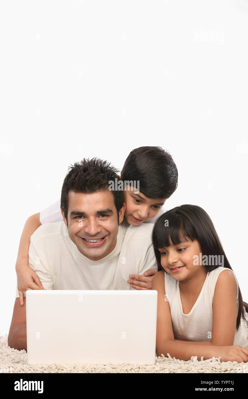 Indian man working on a laptop with his children Stock Photo - Alamy