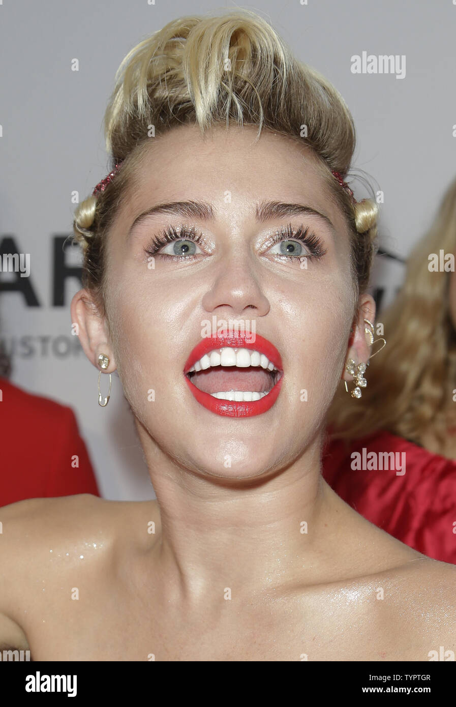 Miley Cyrus arrives on the red carpet at the 2015 amfAR Inspiration ...