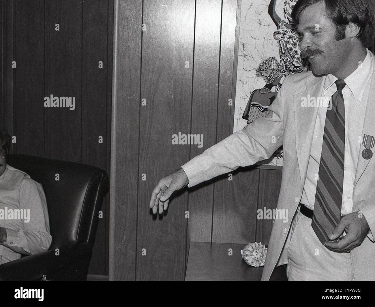 MAN GREETING WOMAN SITTING DOWN. 8-16-78 JIM SCHILL Stock Photo - Alamy