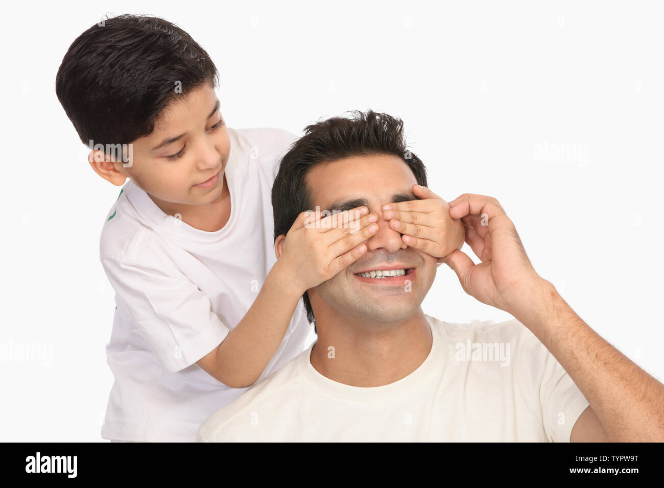 Boy covering father eyes from behind Stock Photo - Alamy