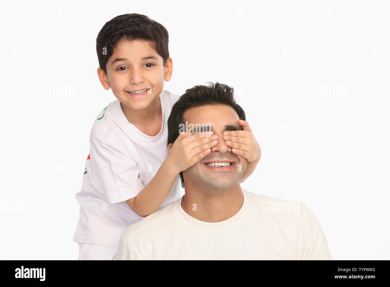 Boy covering father eyes from behind and smiling Stock Photo - Alamy