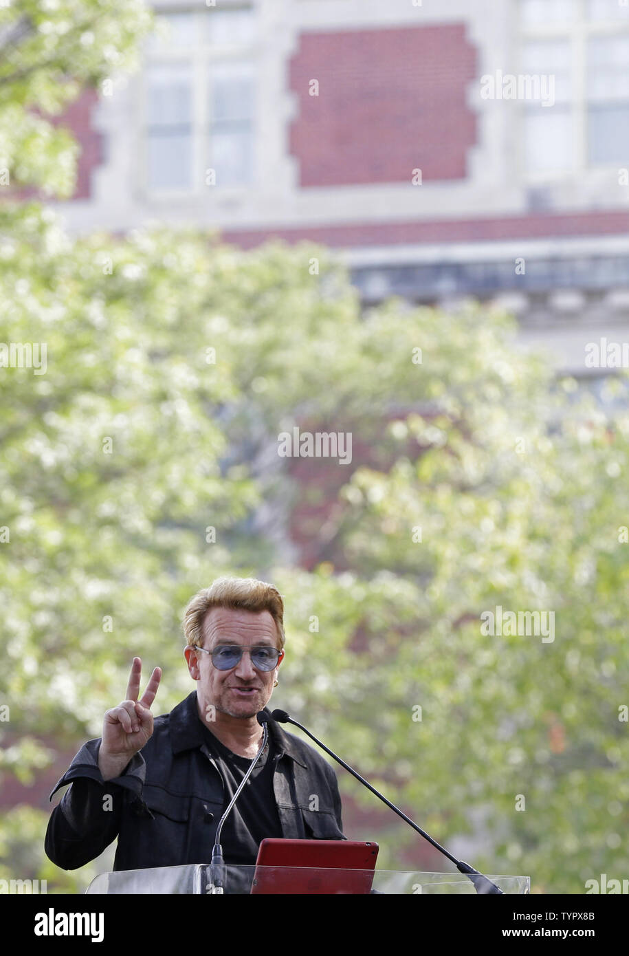 Bono of U2 puts up the peace sign as he makes a speech before the ...