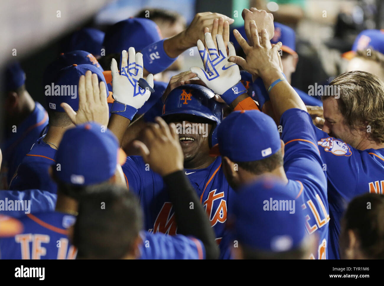 New York Mets Juan Uribe celebrates with teammates in the dugout after ...