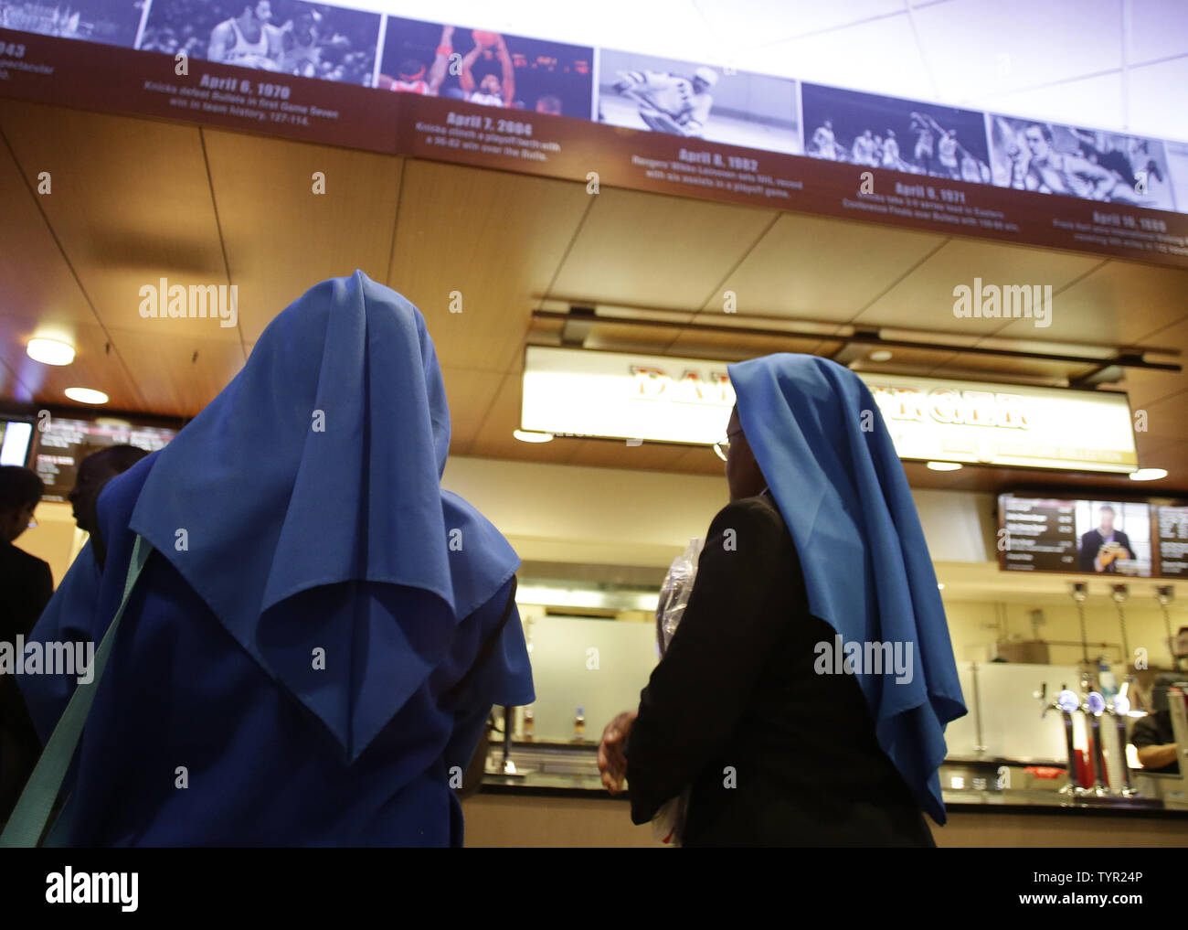 Two nuns wait on line to order from a concession stand in the hall ...