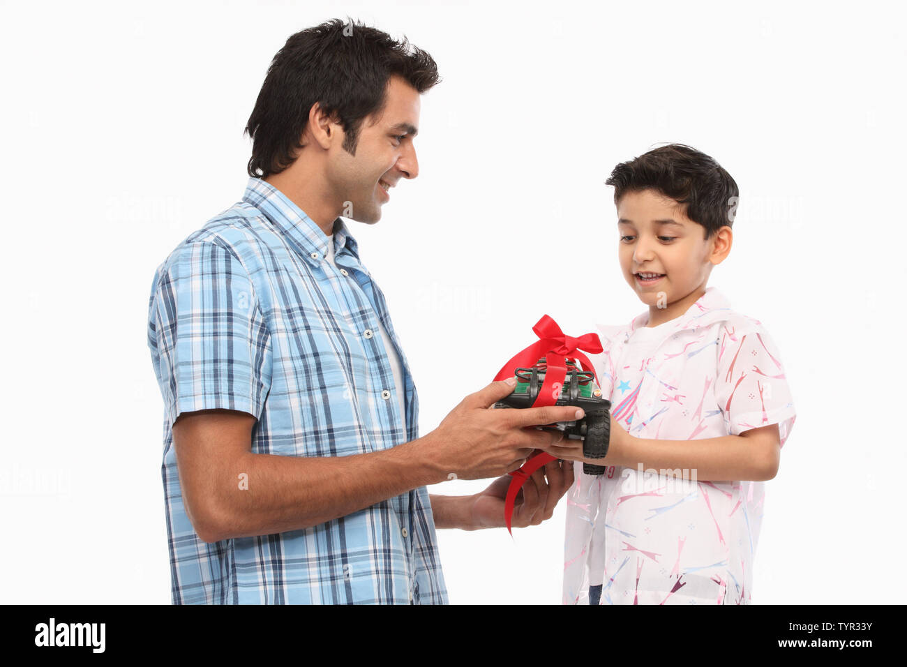 Indian man giving gift to his son Stock Photo - Alamy