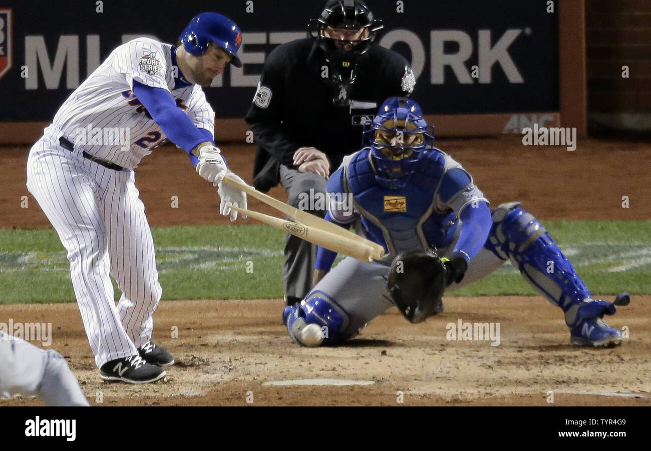 New York Mets batter Daniel Murphy (L) breaks his bat as he grounds out ...