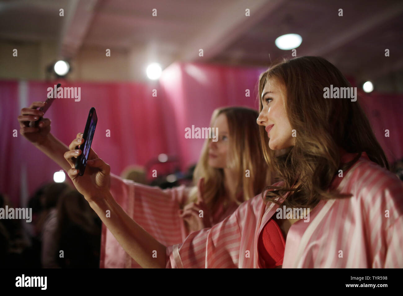 Models take selfies backstage during hair and makeup before the ...
