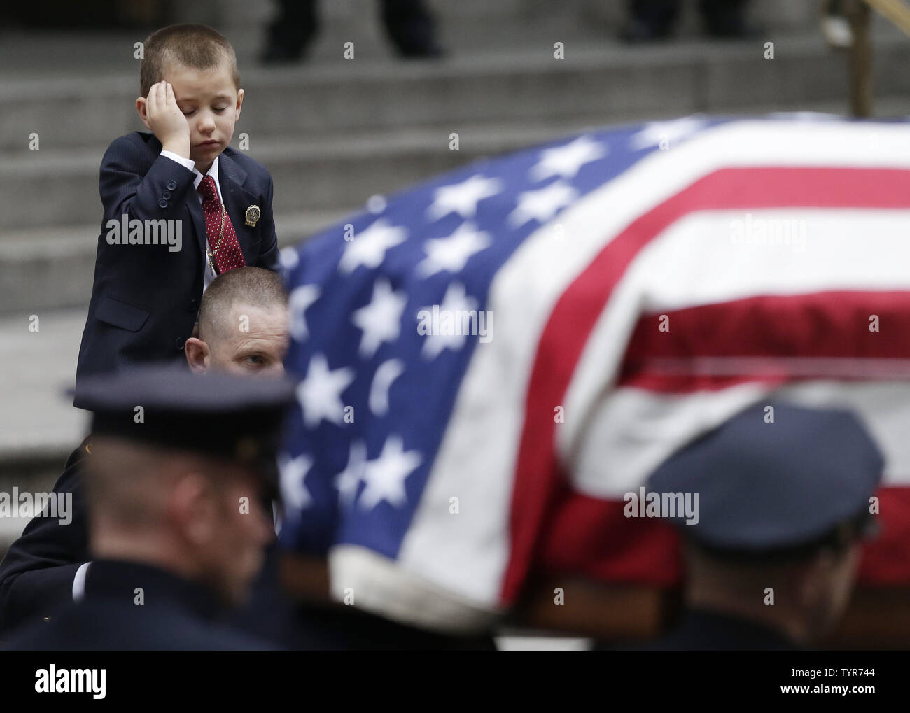Detective Joseph Lemm's 4-year-old son salutes at a casket containing ...