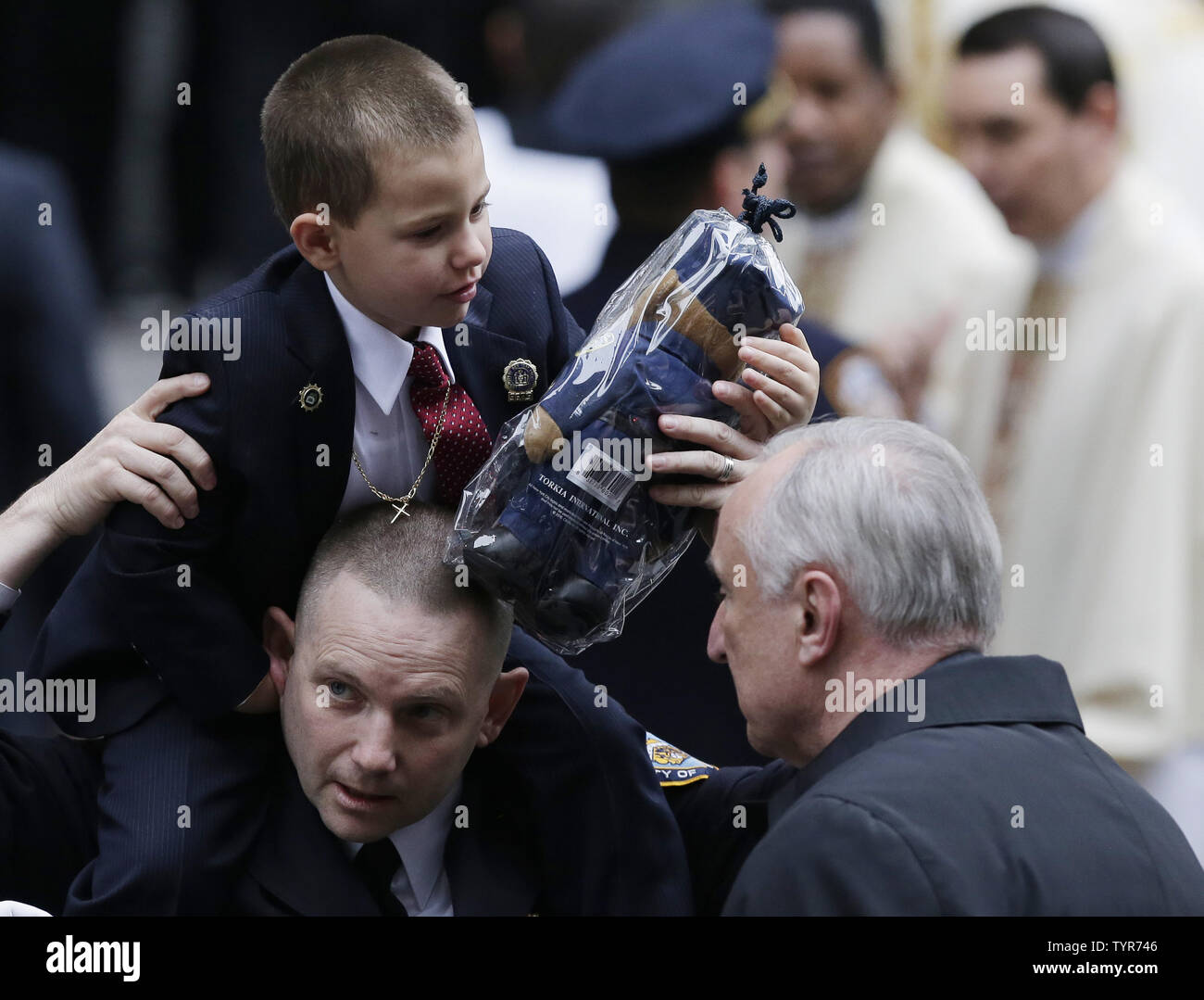 Police Commissioner Bill Bratton gives a toy to Detective Joseph Lemm's ...