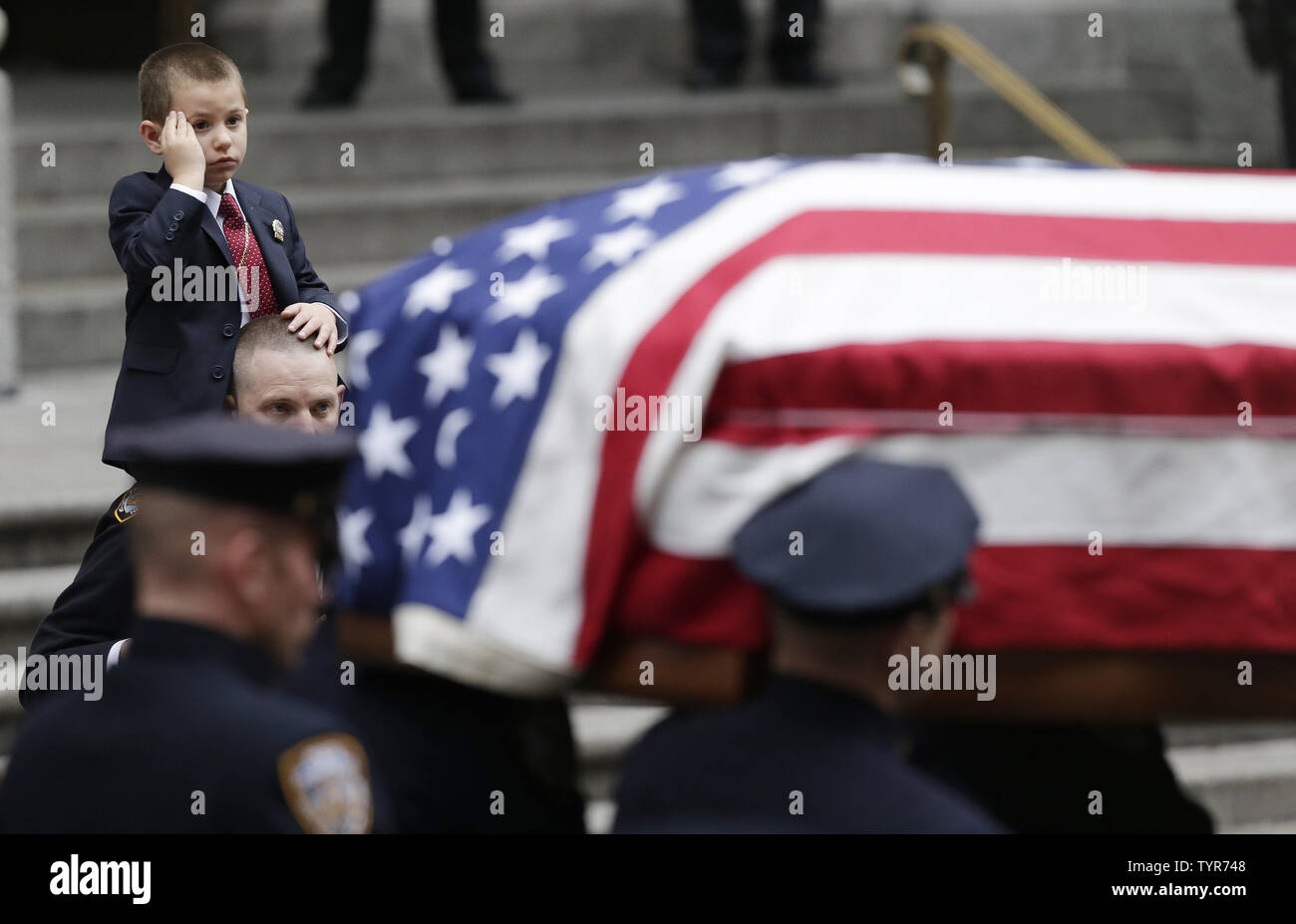Detective Joseph Lemm's 4-year-old son salutes at a casket containing ...