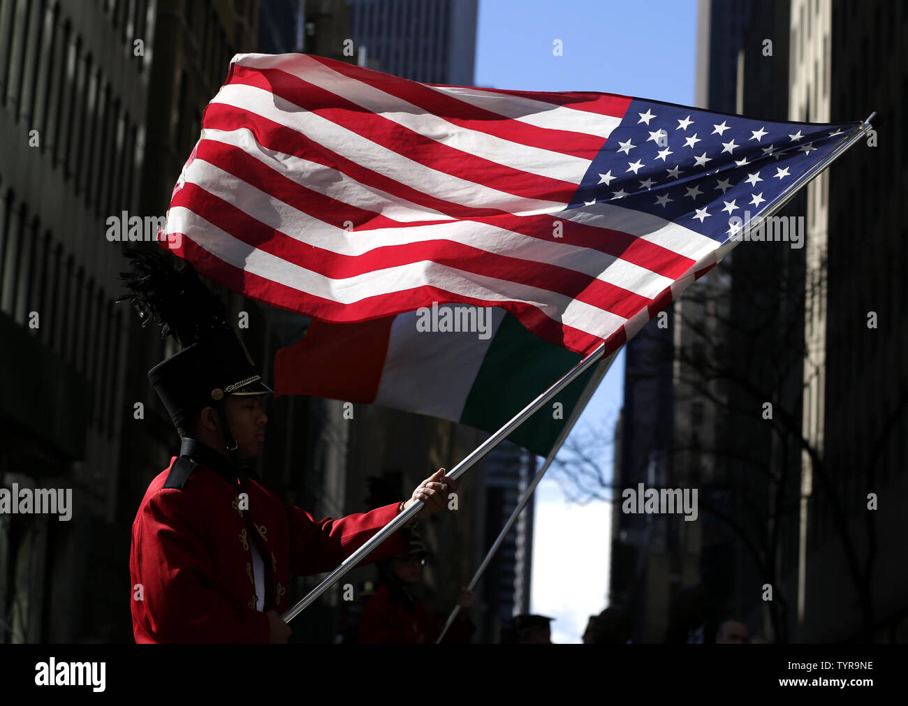 A man carrying an American Flag marches down the parade route at the St ...