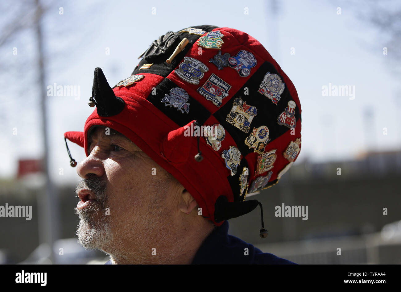 A fan wearing a hat with Yankee pennant pins stands outside at the ball ...