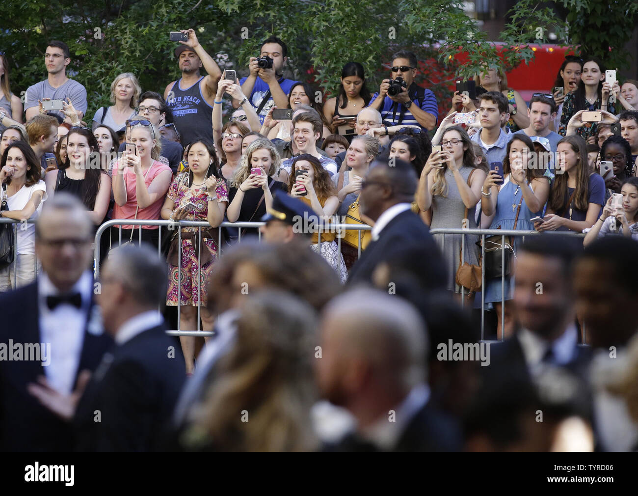 Fans watch the celebrities as they on the red carpet at the 70th Annual ...
