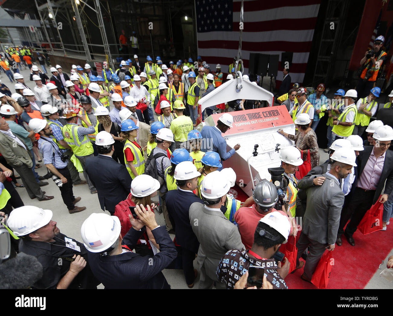 Construction workers sign the last concrete bucket at the topping out ...