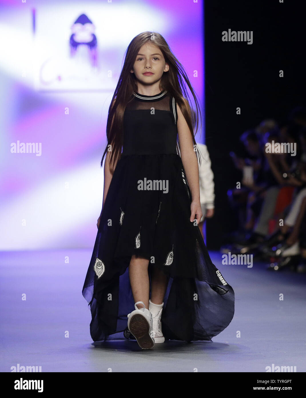 A child model walks on the runway at the Comme Tu Es fashion show ...