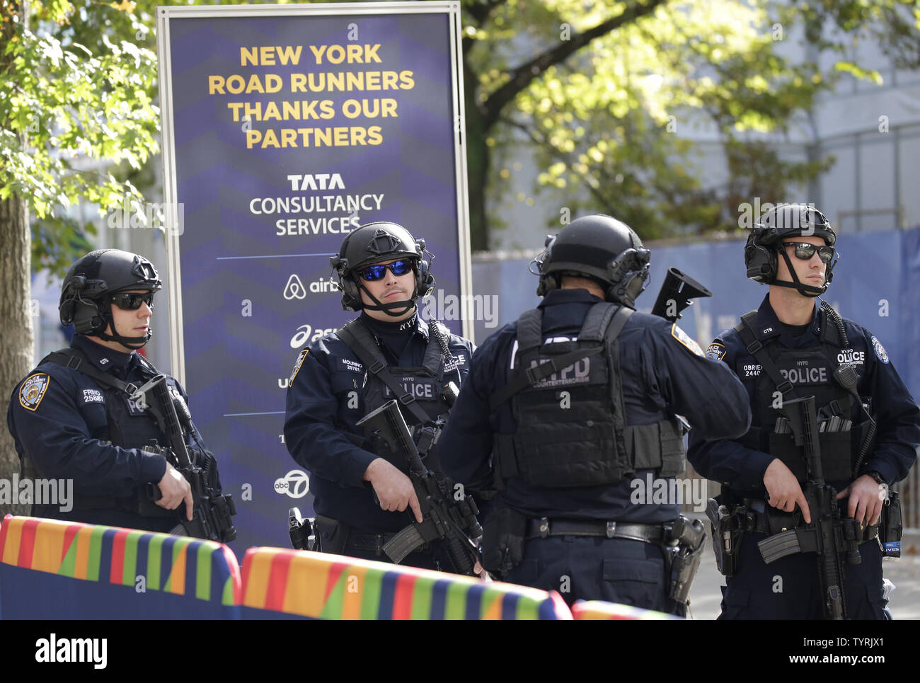 Heavily armed NYPD police officers gather near the entrance to the ...