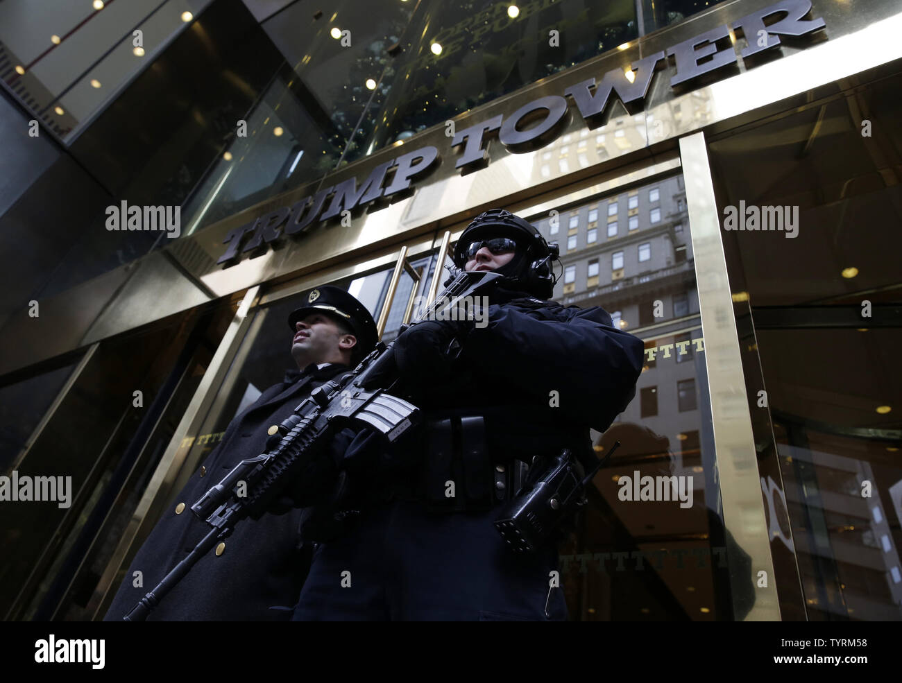 An armed NYPD police officer stands guard outside the entrance to Trump ...