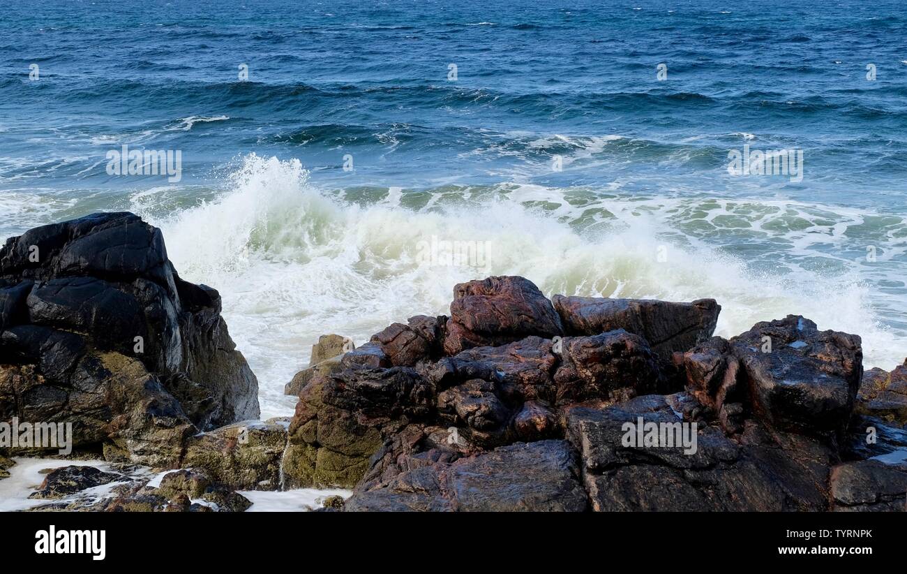 wave splashing on a rock formation at the beach Stock Photo - Alamy