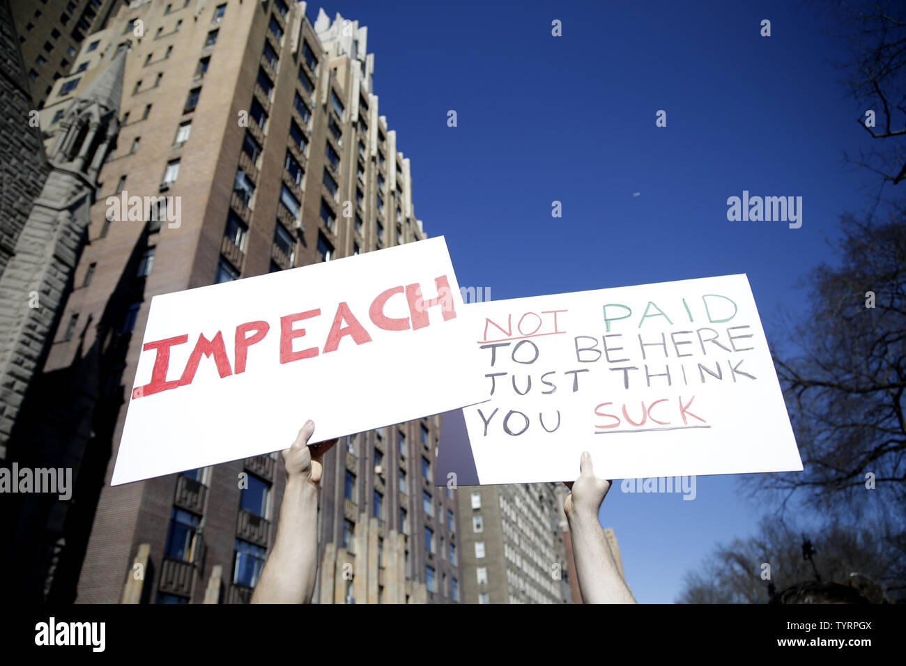 Protesters hold up Impeach signs at the "Not My President's Day" rally ...
