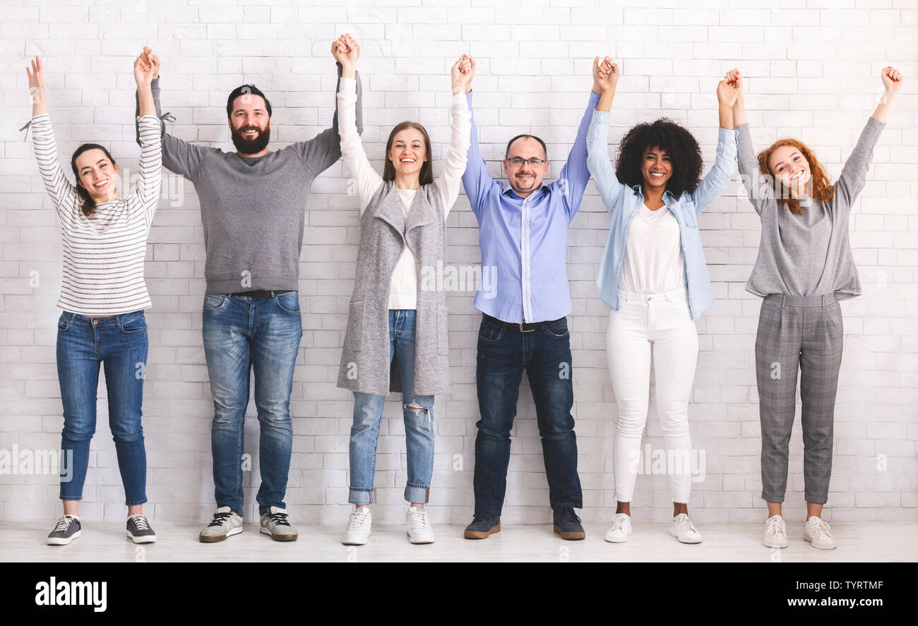 Group of successful friendly people raising connected hands Stock Photo ...