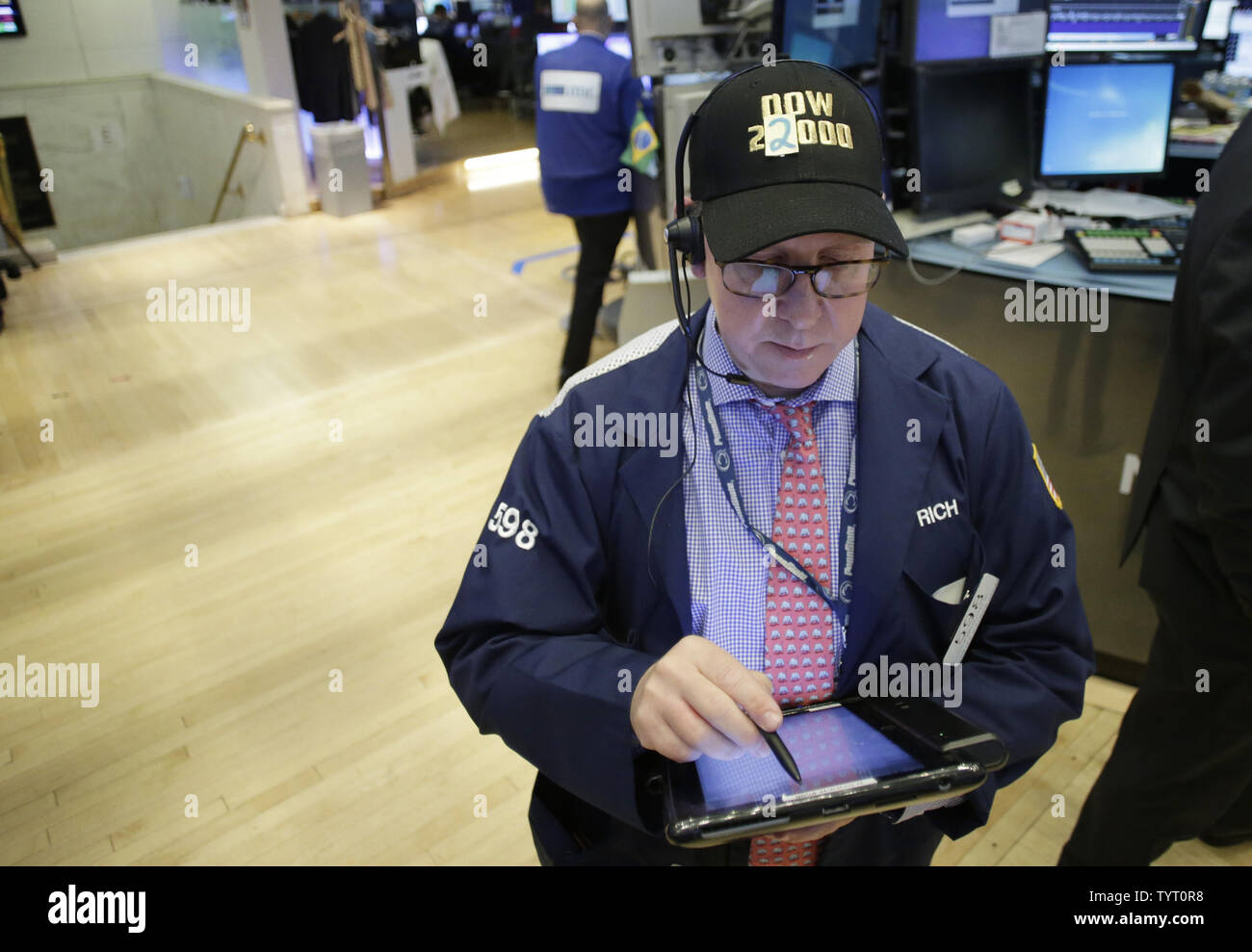 A trader on the floor of the NYSE wears a DOW 22,000 hat after the ...