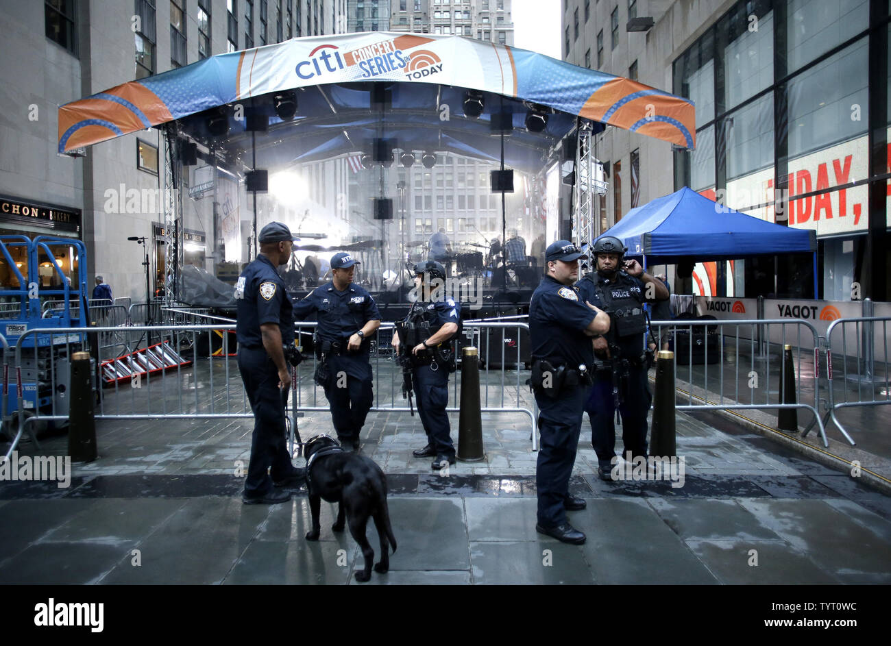 NYPD police officers stand behind the stage on an evacuated Plaza ...