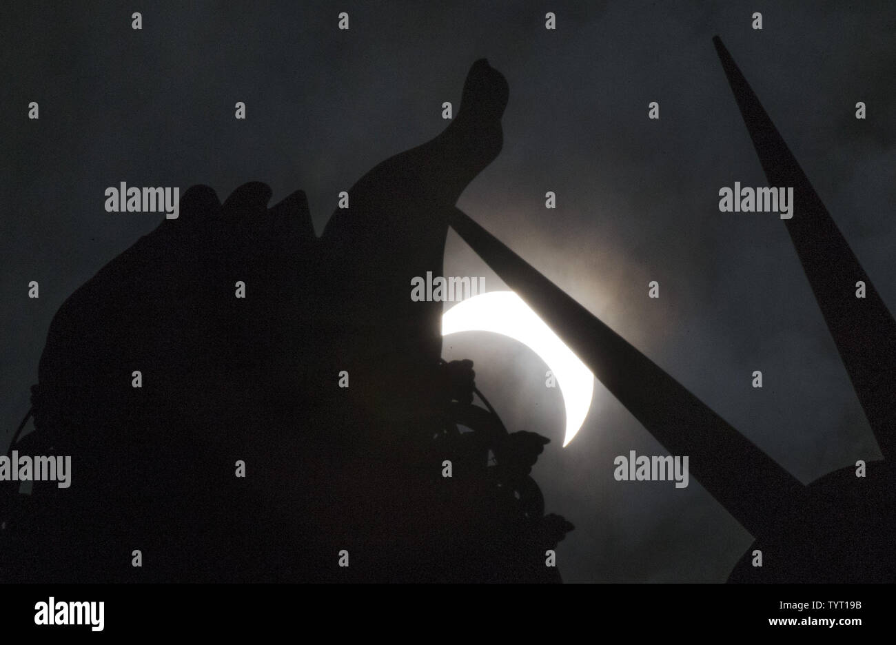 A partial solar eclipse moves across the sky near the Crown and Torch ...