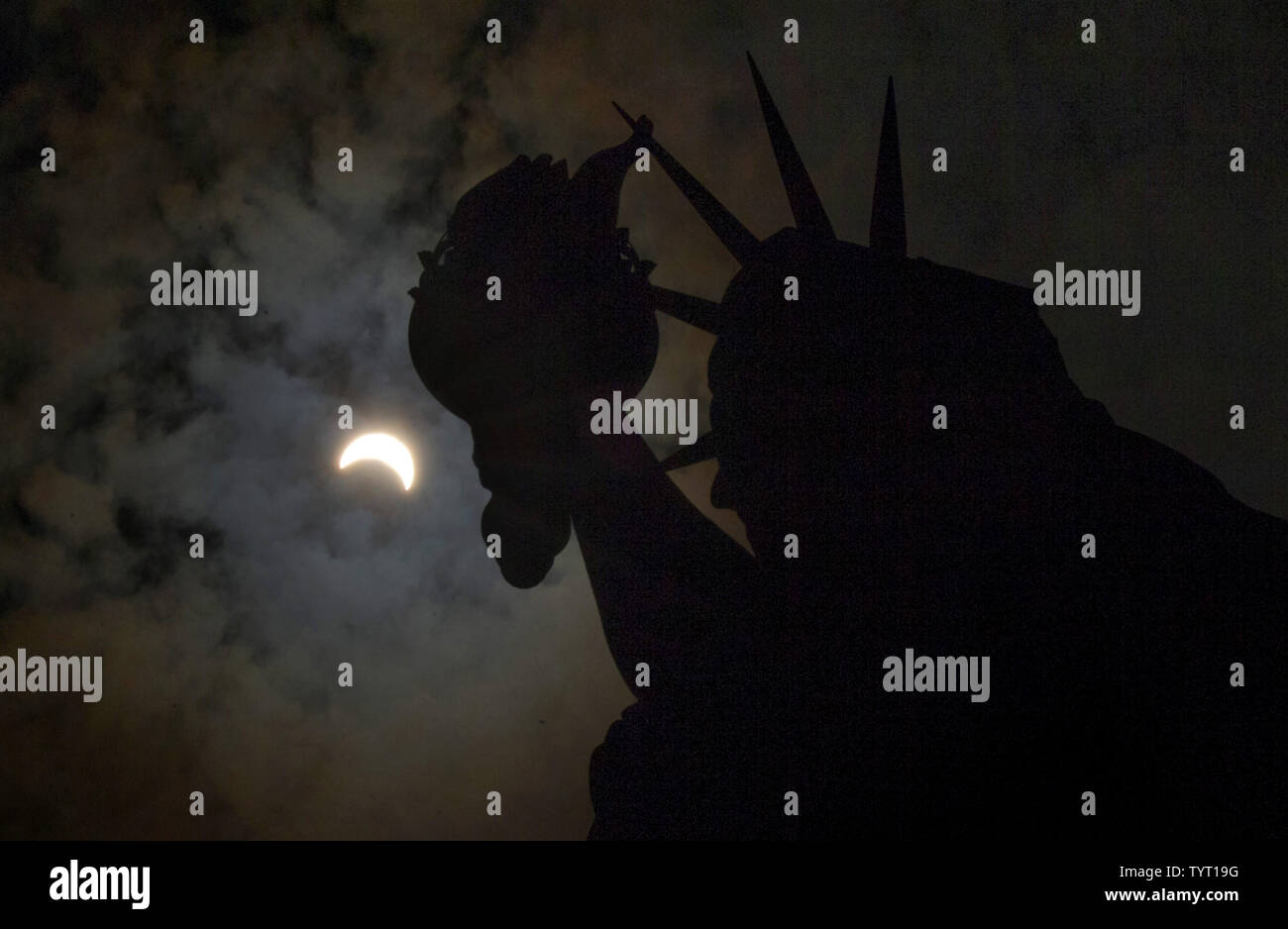 A partial solar eclipse moves across the sky near the Crown and Torch ...