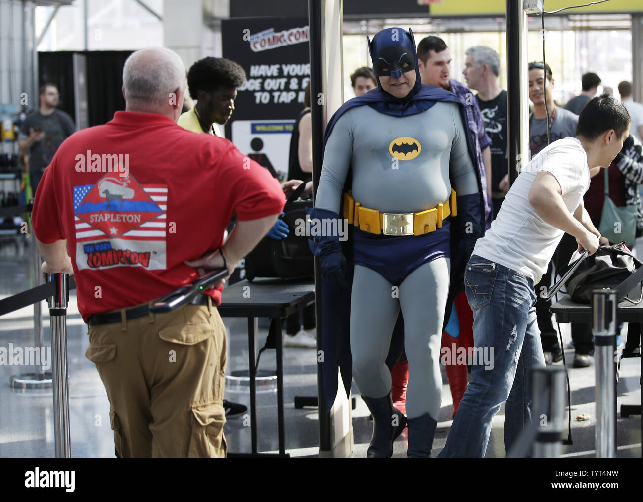 A cosplayer dressed as Batman walks through security at New York Comic ...