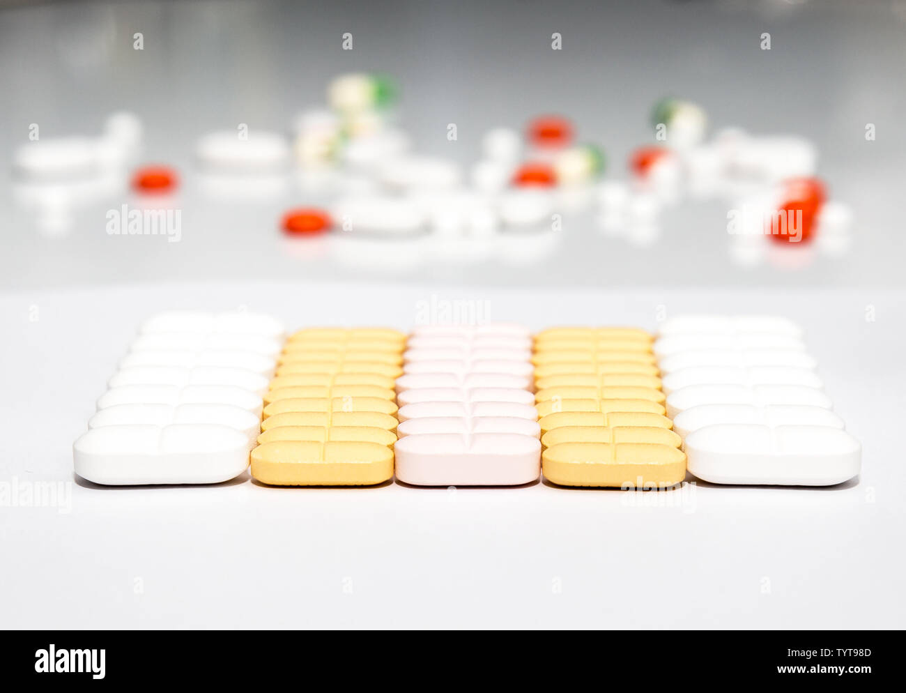 Pills of different sizes in a row Stock Photo - Alamy