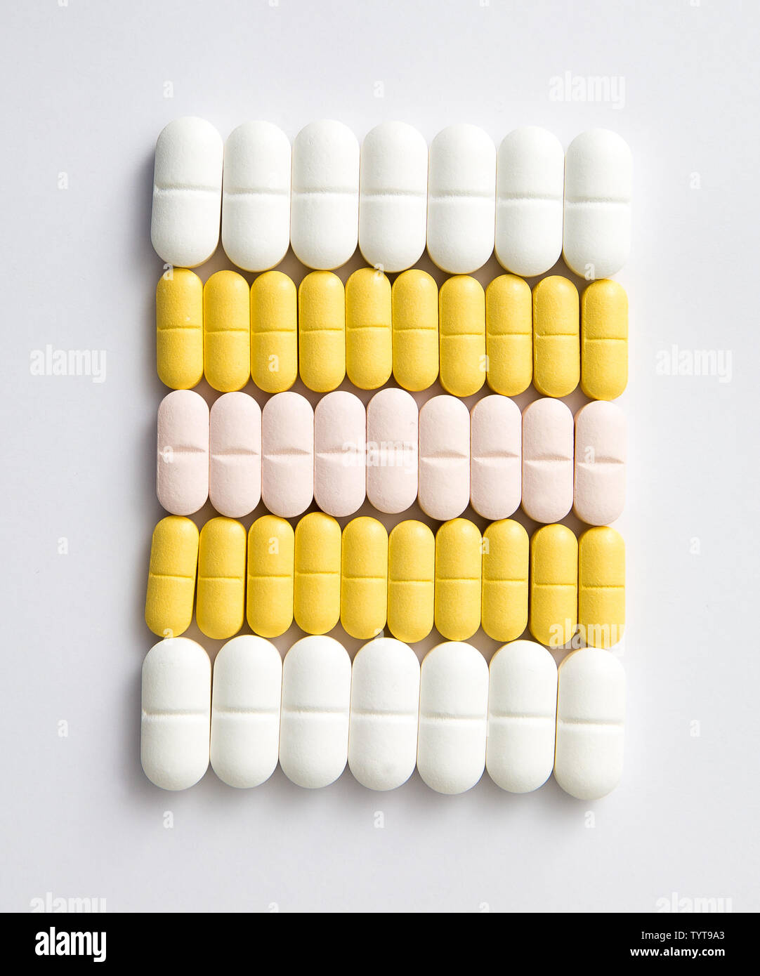 Pills of different sizes in a row Stock Photo - Alamy