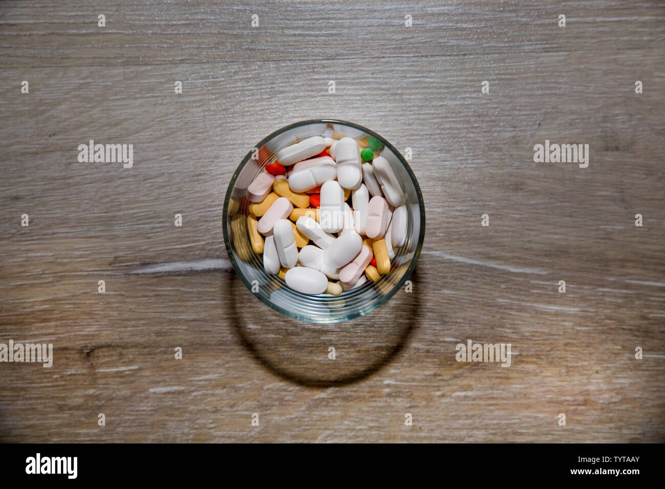 Pills of different size in glass Stock Photo - Alamy