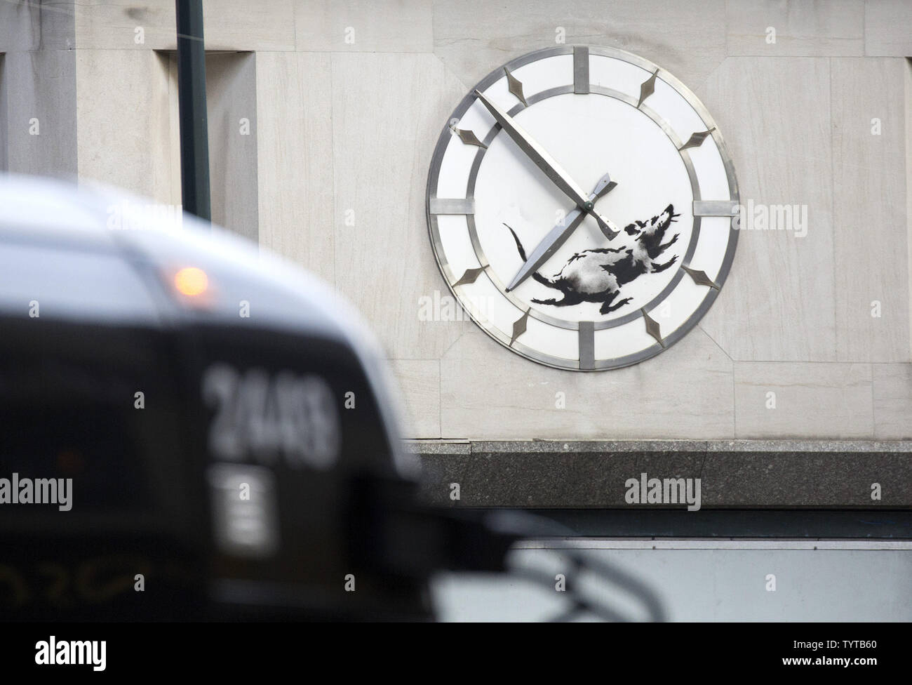 A painting of a rat running in a street clock face like a hamster wheel ...