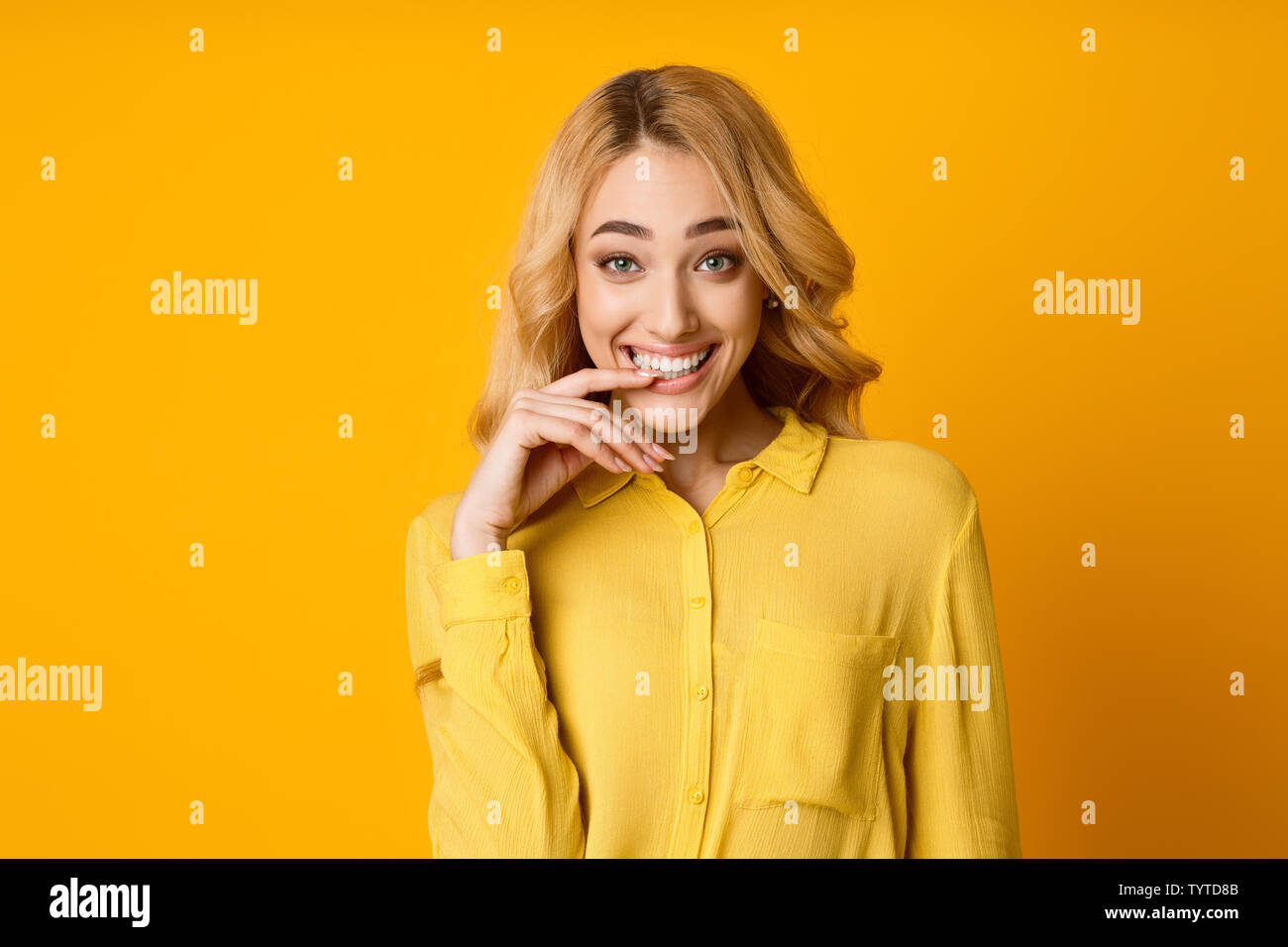 Girl Flirtatiously Holding Finger at Open Mouth Stock Photo - Alamy