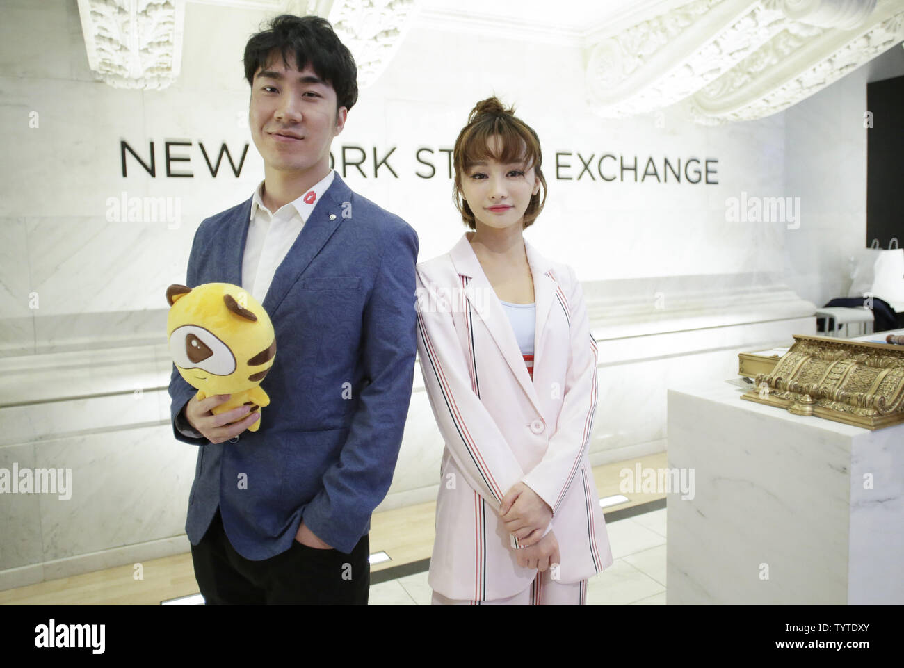Tao Jiang and Yiying Han hold the brand Mascot for Huya Inc.on the ...