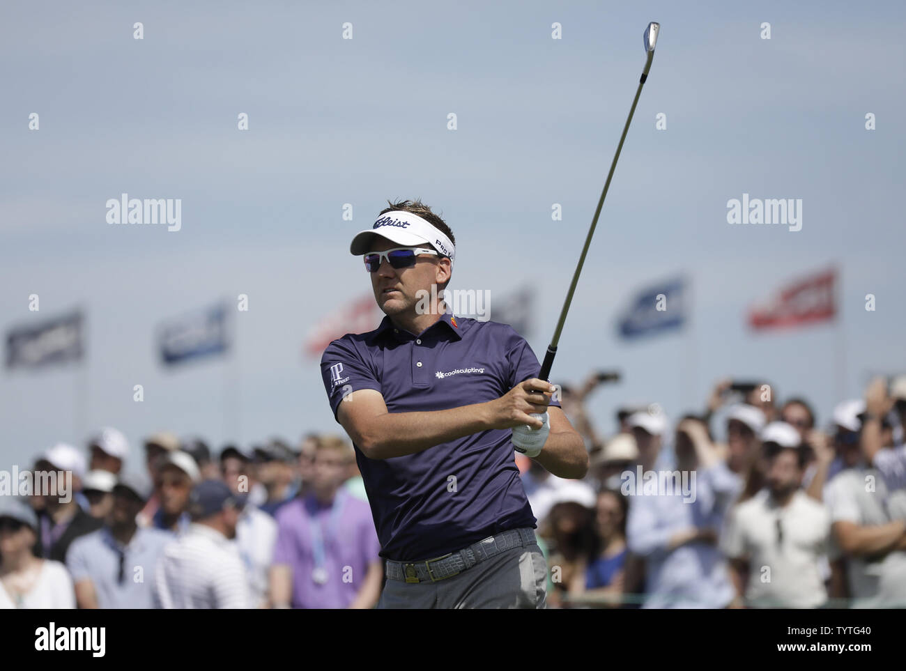 Ian Poulter from England hits his tee shot on the first hole in the ...