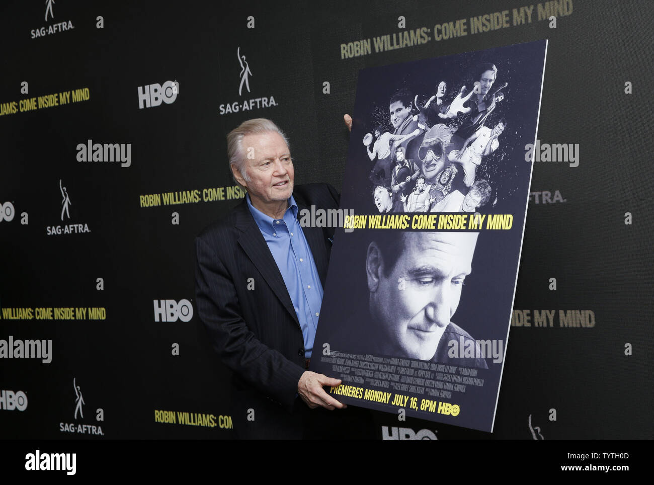 Jon Voight holds up the movie poster when he arrives on the red carpet ...