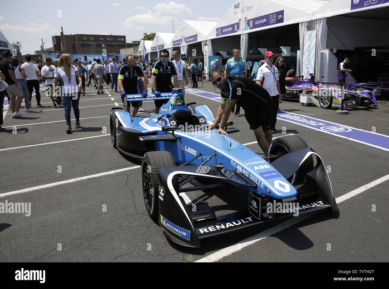 Formula E race cars are worked on in the Pit area at the the track ...