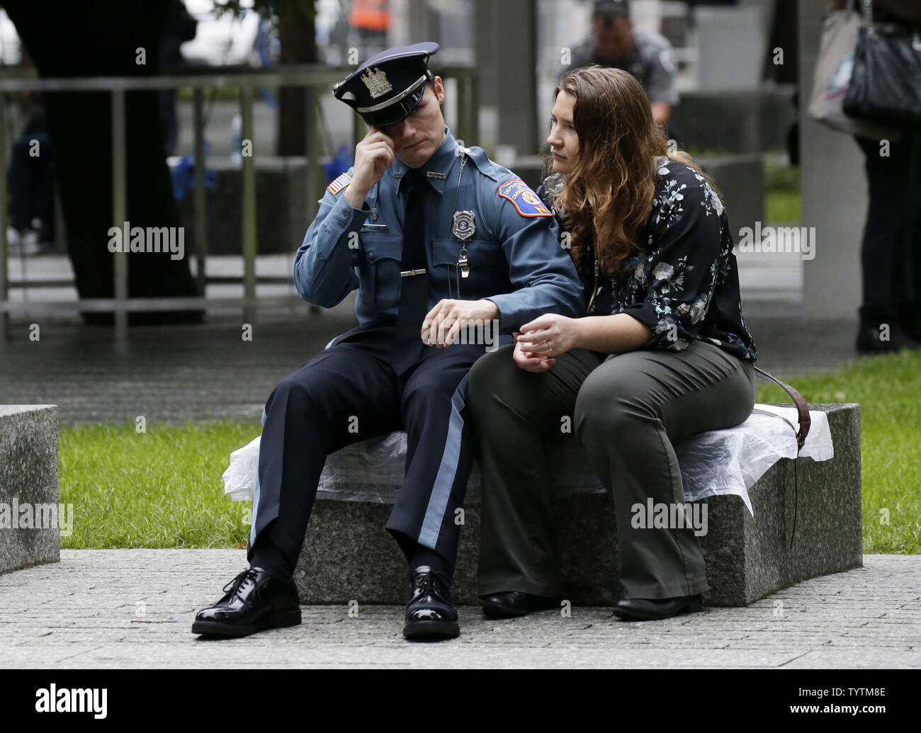 A woman sits with an NYPD police officer on a bench as the victims ...
