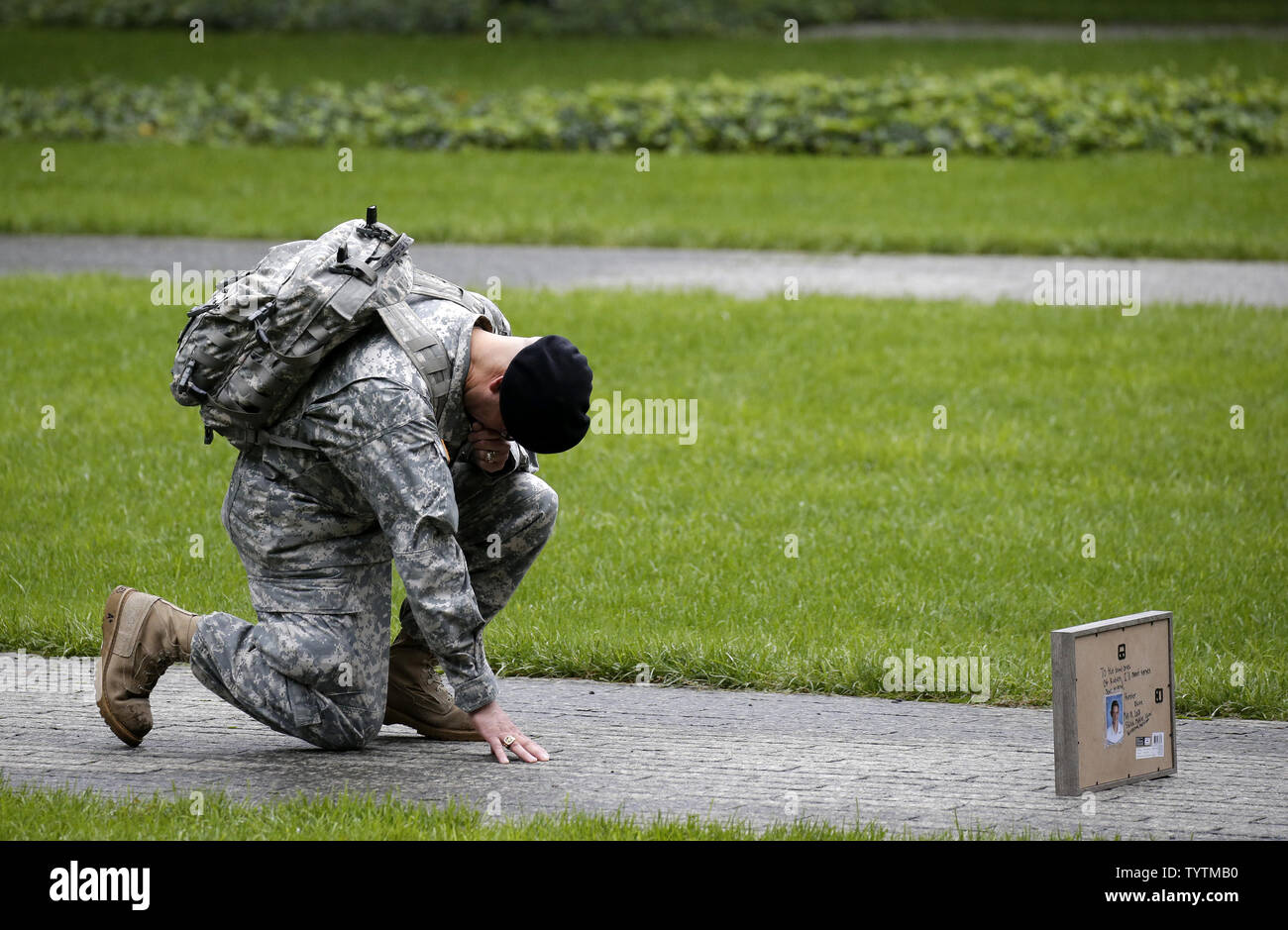 A man in uniform kneels before a photo at the 9/11 ceremony near the ...