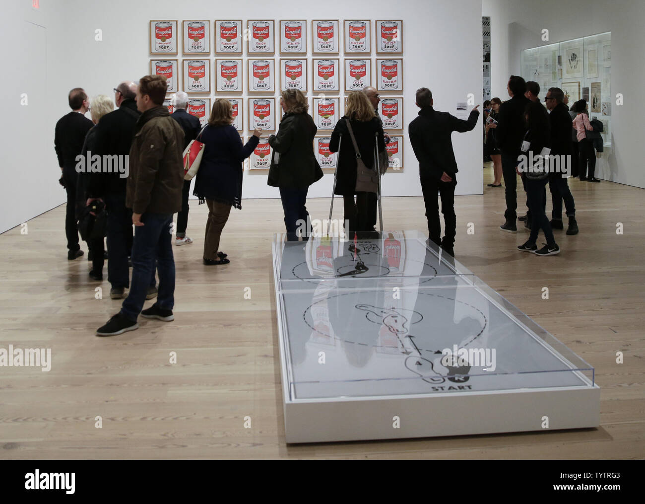 People stand among works of art by Andy Warhol at a member preview for the upcoming exhibit ...