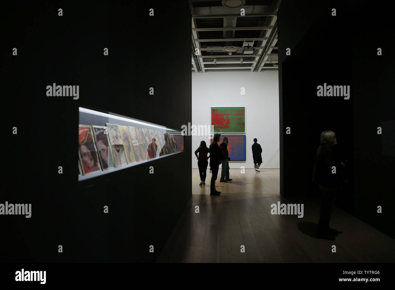 People stand among works of art by Andy Warhol at a member preview for the upcoming exhibit ...