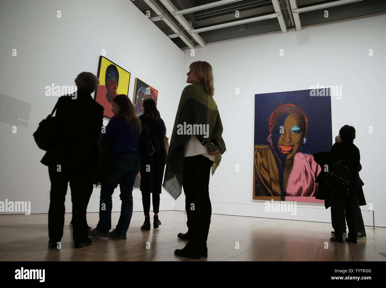 People stand among works of art by Andy Warhol at a member preview for the upcoming exhibit ...
