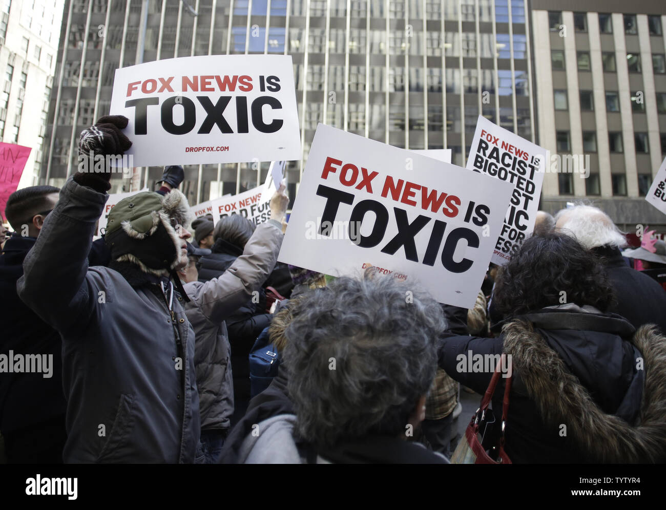 Protesters hold up signs at a rally against Fox News outside the Fox ...