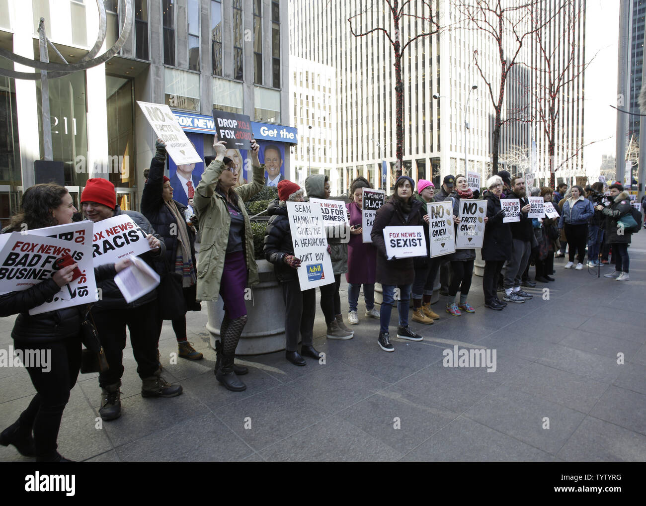 Protesters hold up signs at a rally against Fox News outside the Fox ...