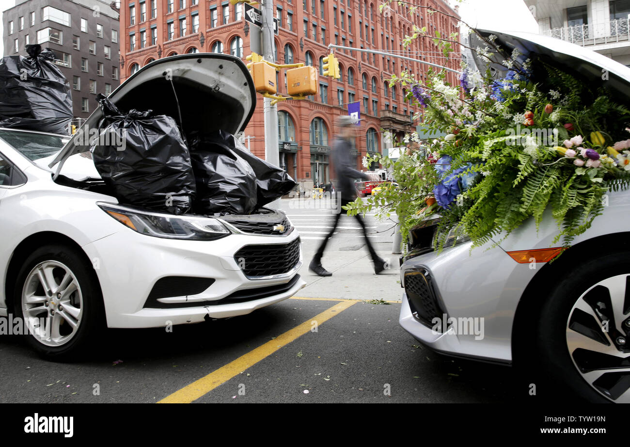 A car filled with flowers is parked opposite a car filled with trash ...