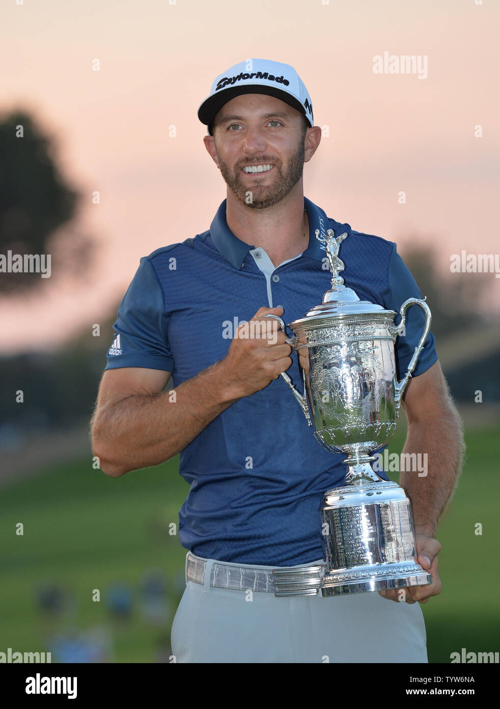 Dustin Johnson holds the Championship Trophy on the 18th green after ...