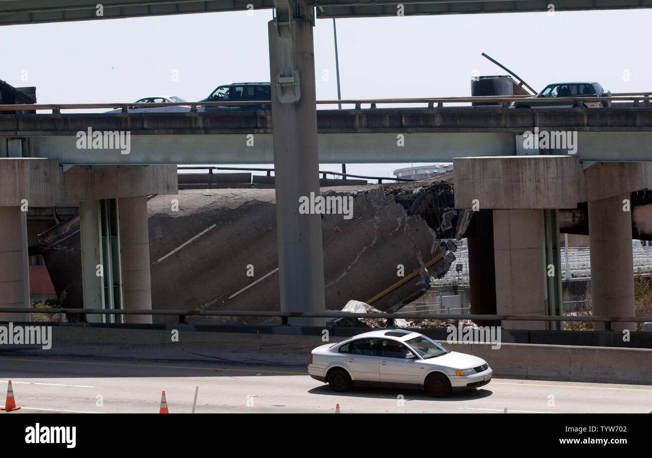 Traffic makes its way past a section of collapsed highway near the San ...