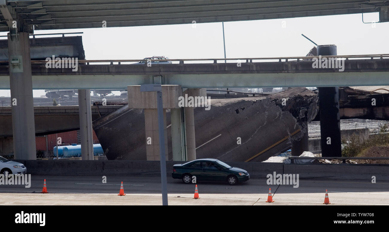 Traffic makes its way past a section of collapsed highway near the San ...