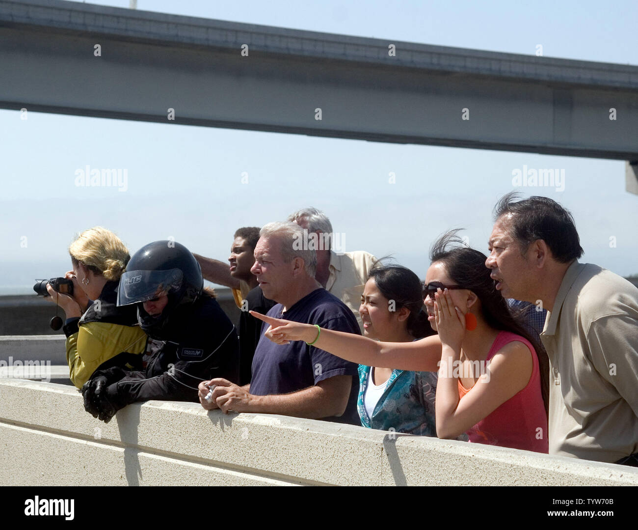 Spectators atop a parking garage in Emeryville, California look at a ...